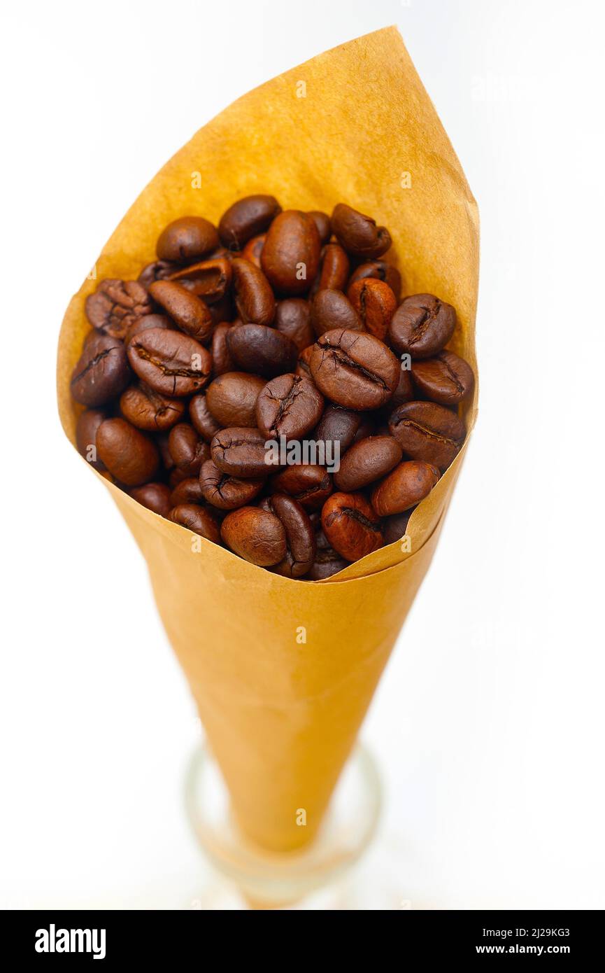 Espresso coffee beans on a paper cone cornucopia over white background ...