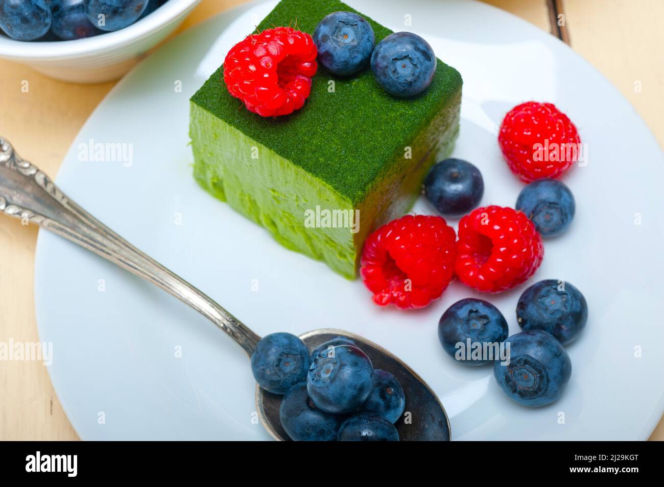Green tea matcha mousse cake with raspberries and blueberries on top ...