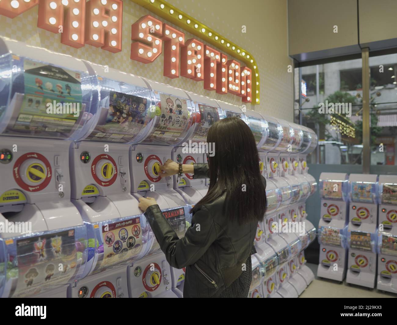 Girl at toy vending machine in Macau, China Stock Photo - Alamy