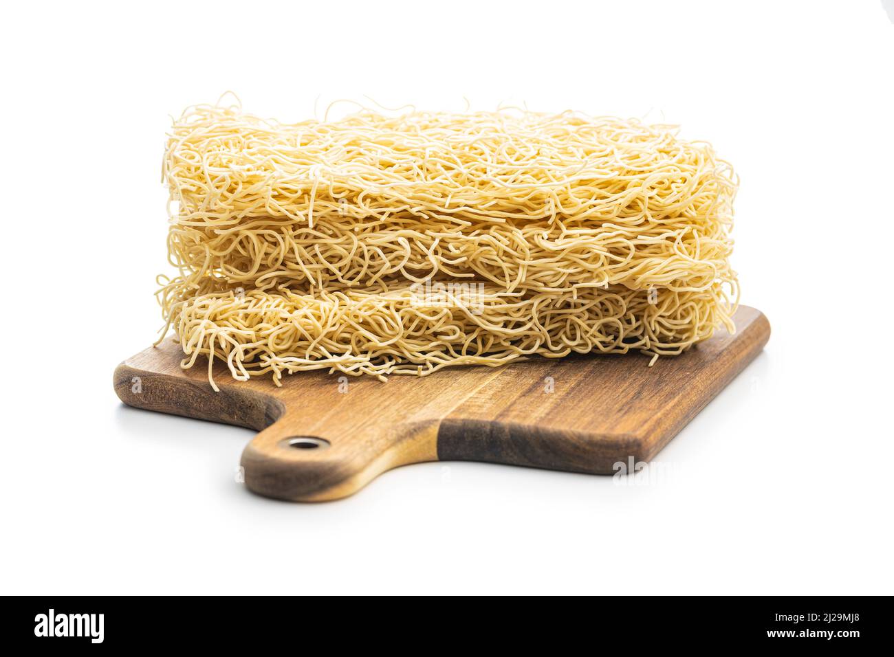 Instant noodles. Uncooked chinese noodles on cutting board isolated on ...