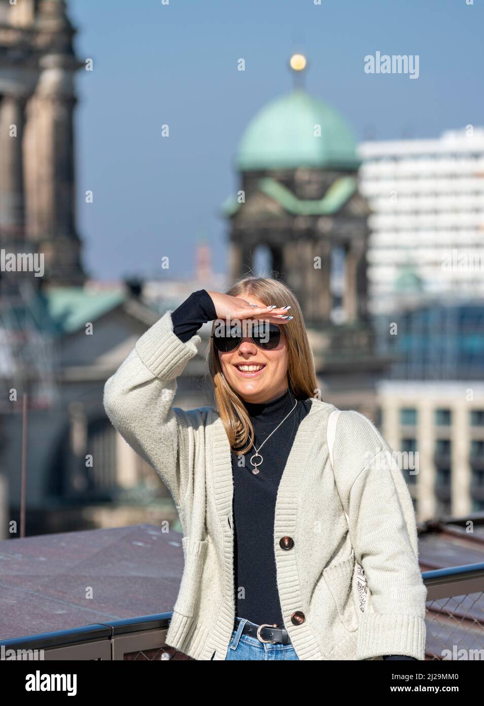 Young woman protects her eyes from the backlight in the sun, Berlin ...