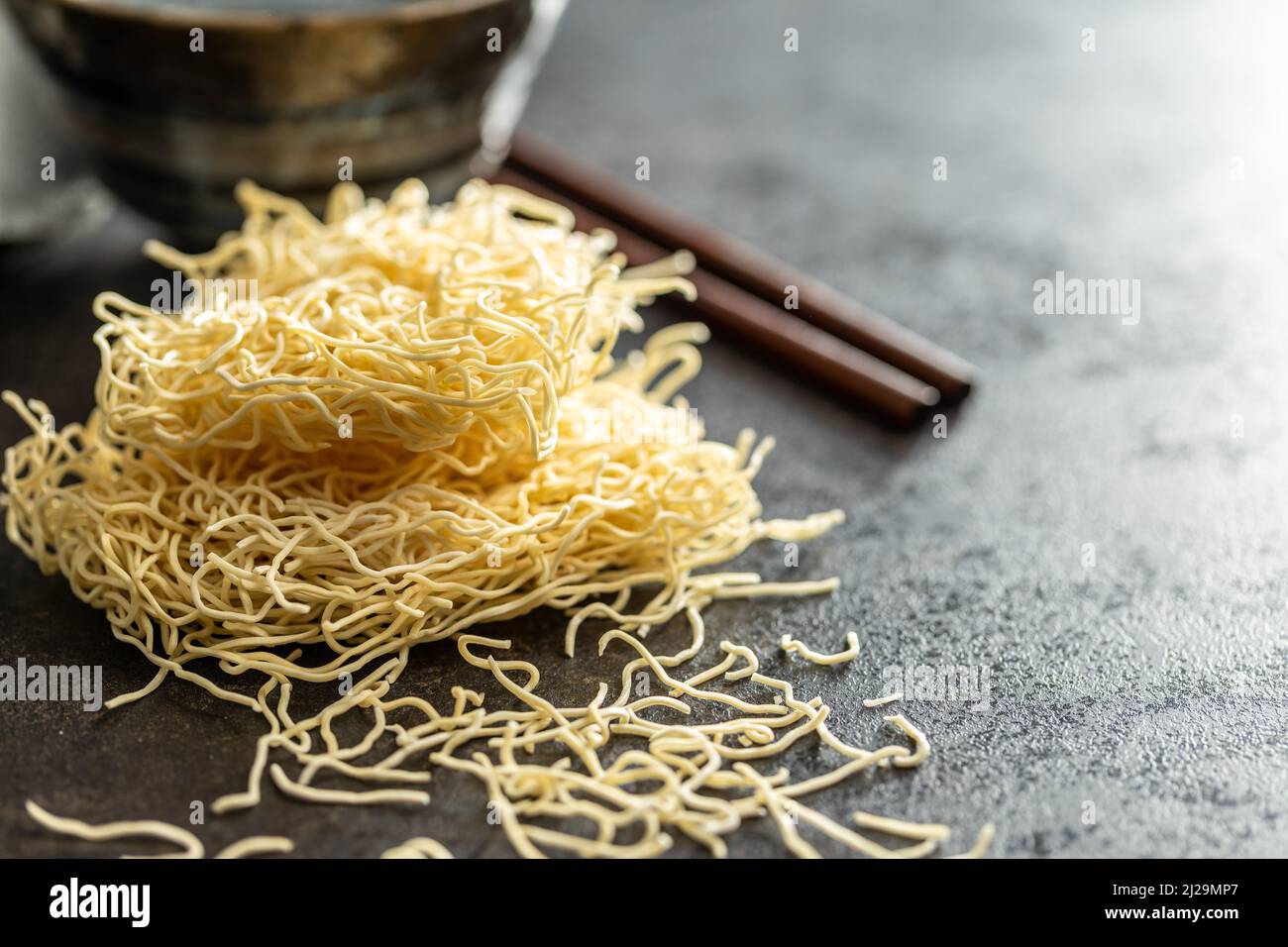 Instant noodles. Uncooked chinese noodles on a black kitchen table ...