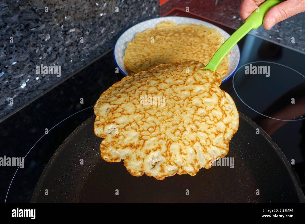 Swabian cuisine, pancakes, frying flaedle in the pan, spatula ...