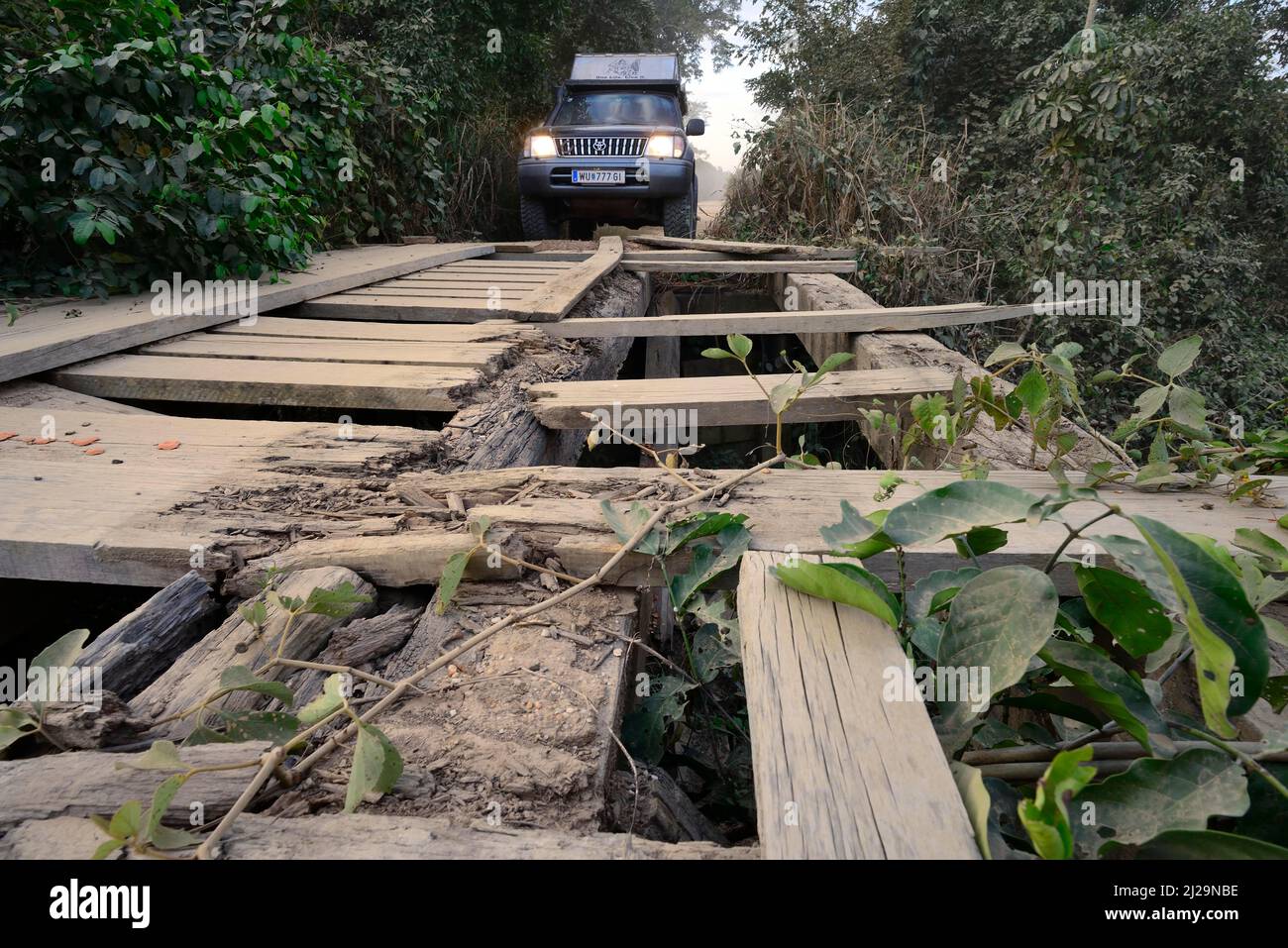 Off-road vehicle in front of a broken wooden bridge on the ...