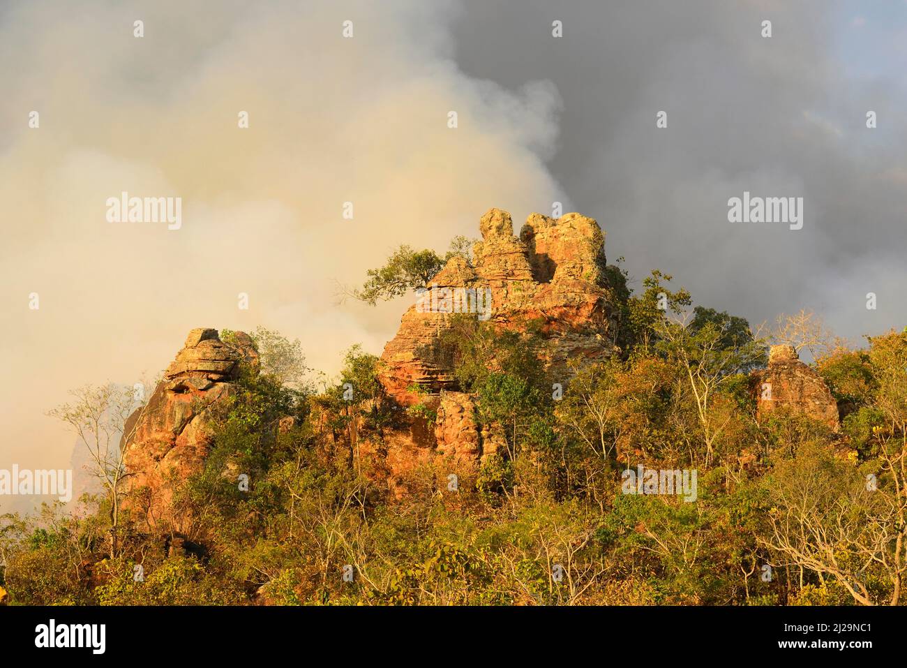 Bizarre rock formation and smoke cloud during a bushfire, Chapada dos ...