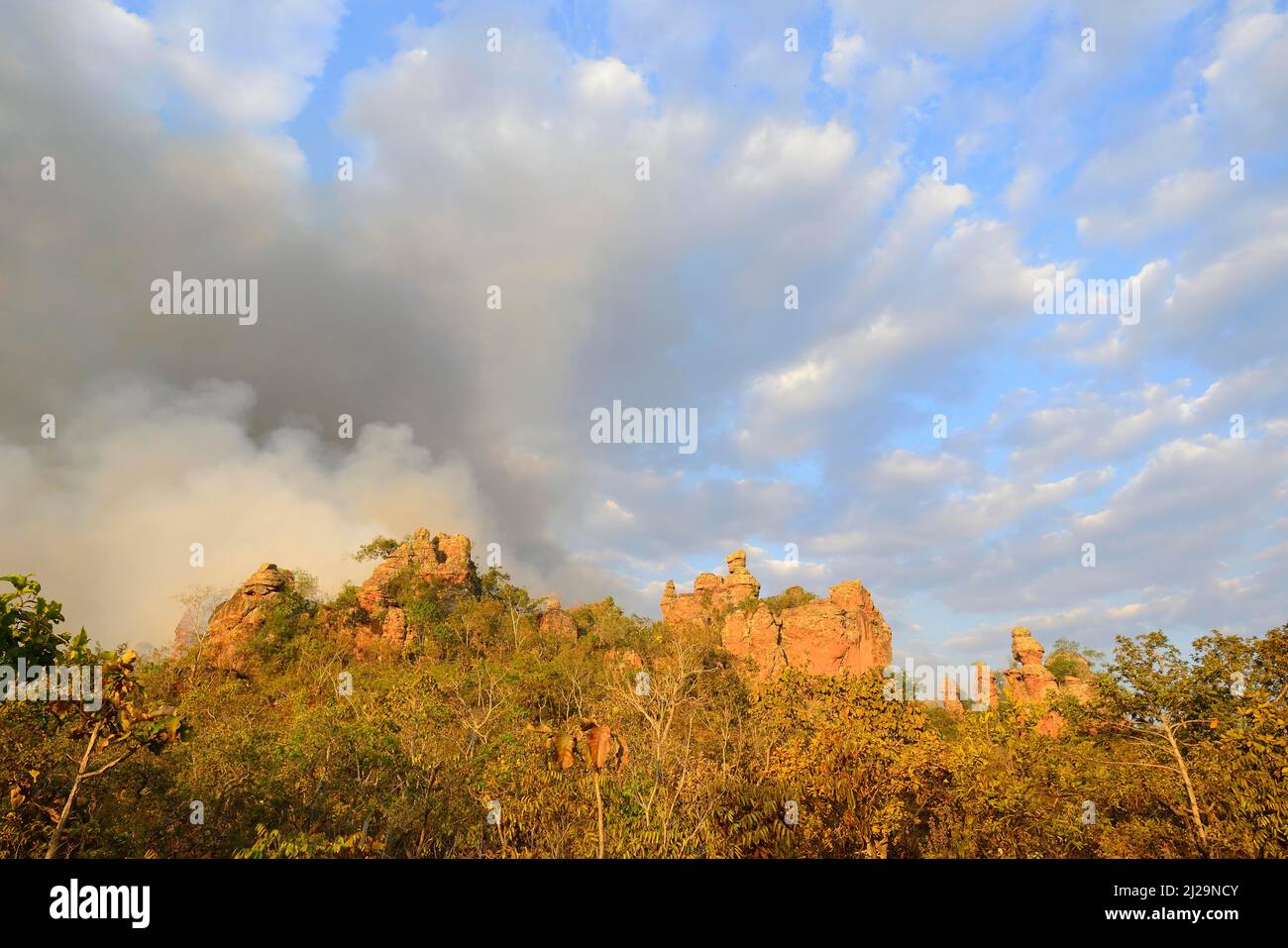 Bizarre rock formation and clouds of smoke during a bushfire, Chapada ...