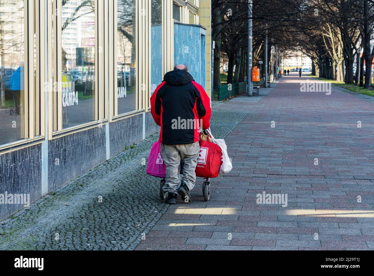 Senior citizen with walking frame and bags full of returnable bottles ...