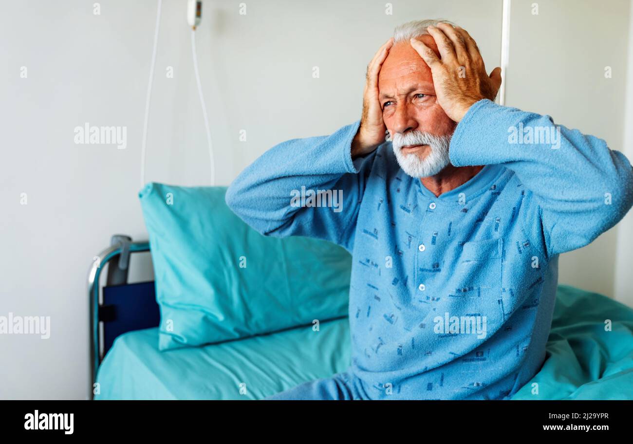 Depressed senior man patient suffering from headache and illness in ...