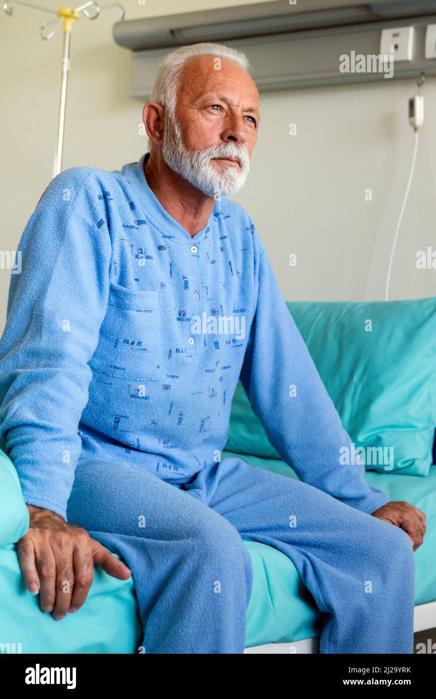 Senior male patient in hospital bed who is recovering from the disease ...