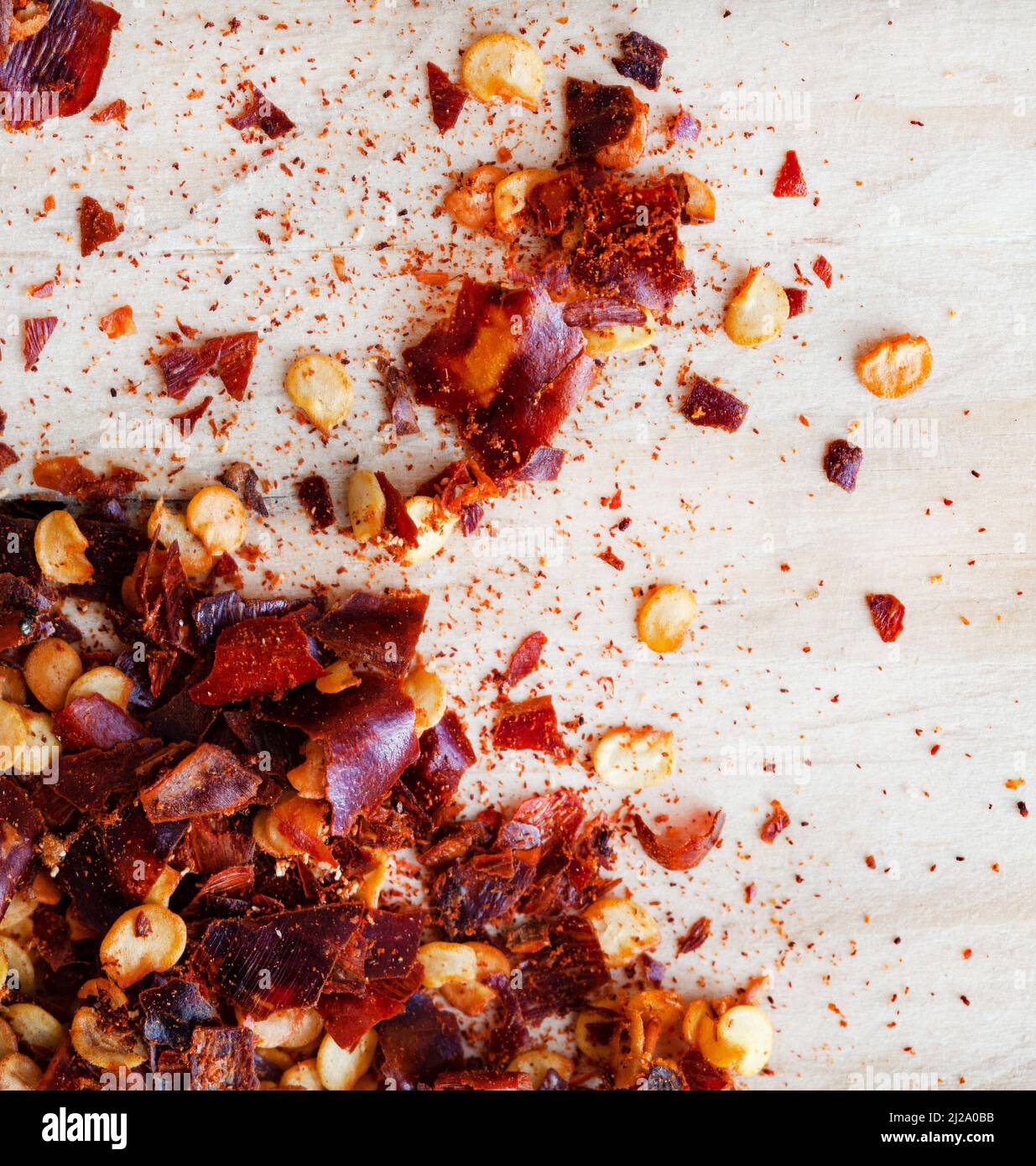 Dried red chili flakes on raw wooden surface Stock Photo - Alamy
