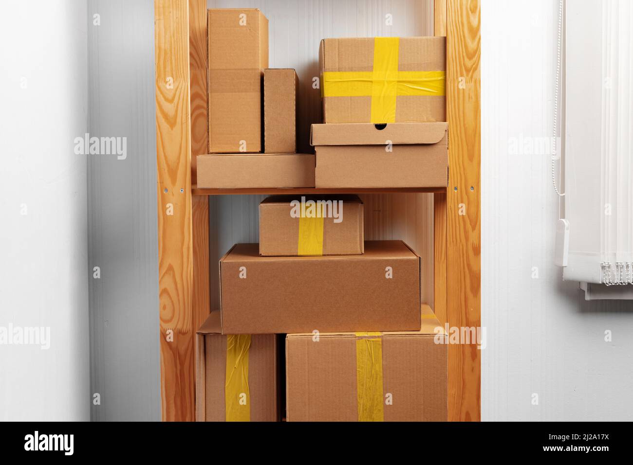 Stack of cardboard package boxes on wooden rack Stock Photo - Alamy
