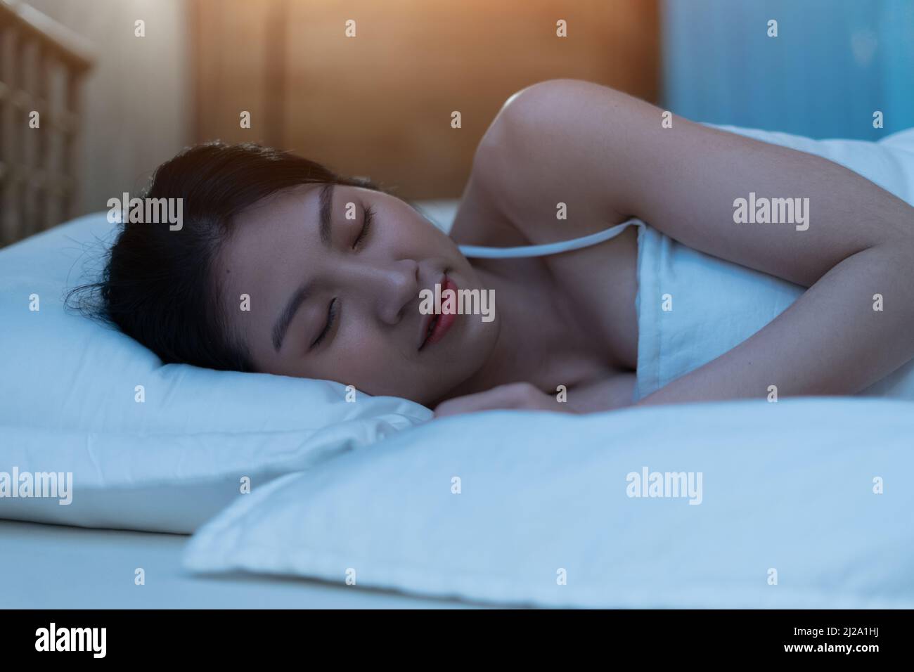 Beautiful young Asian woman is deep asleep and has a beautiful dream ...