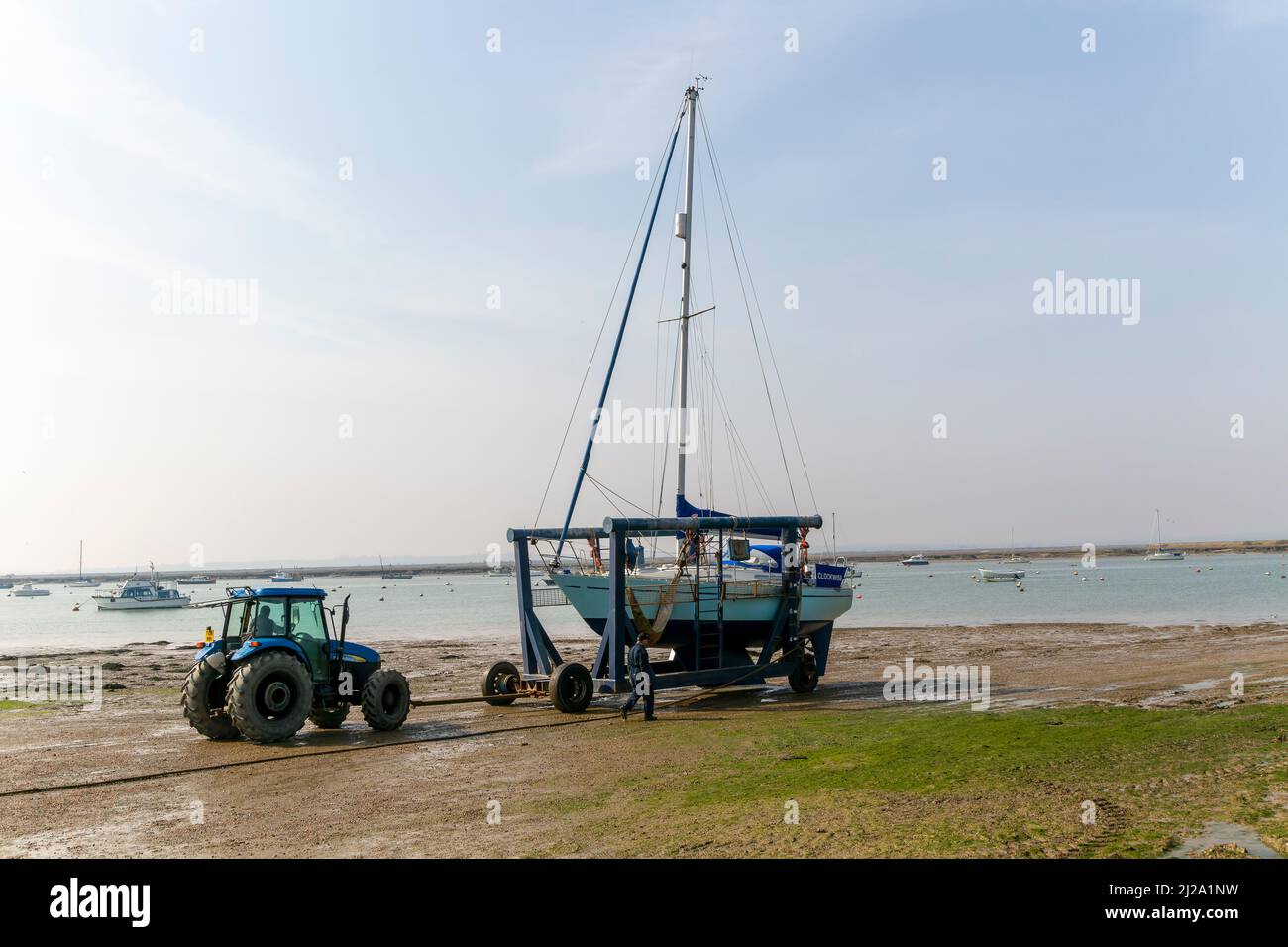 Tractor launching boat in cradle, River Blackwater estuary, West Mersea ...