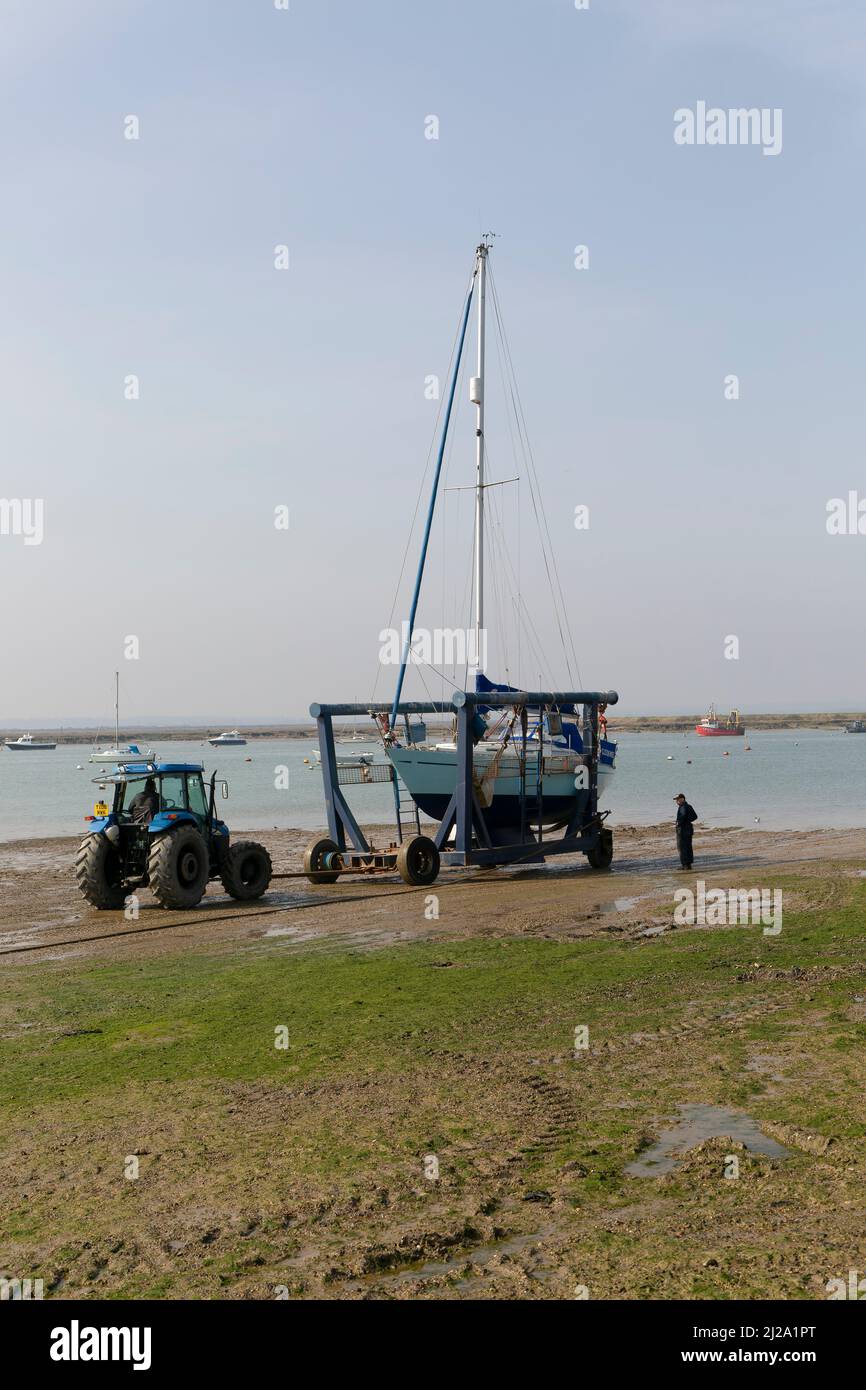 Tractor launching boat in cradle, River Blackwater estuary, West Mersea ...