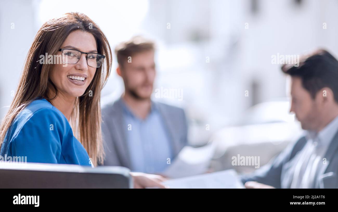 business woman sitting at a table on the background of colleagues Stock ...