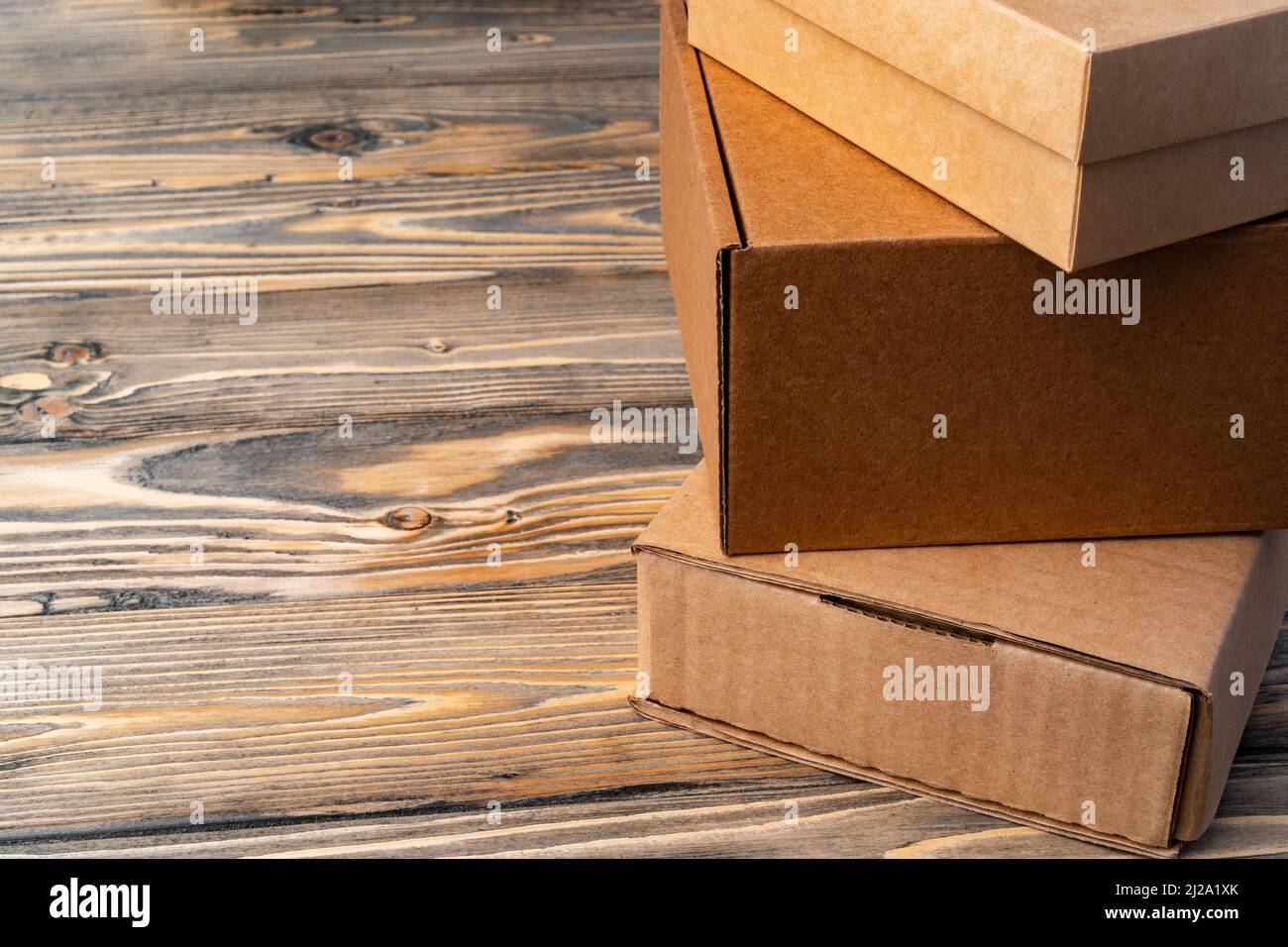 Pile of cardboard boxes on wooden background Stock Photo - Alamy