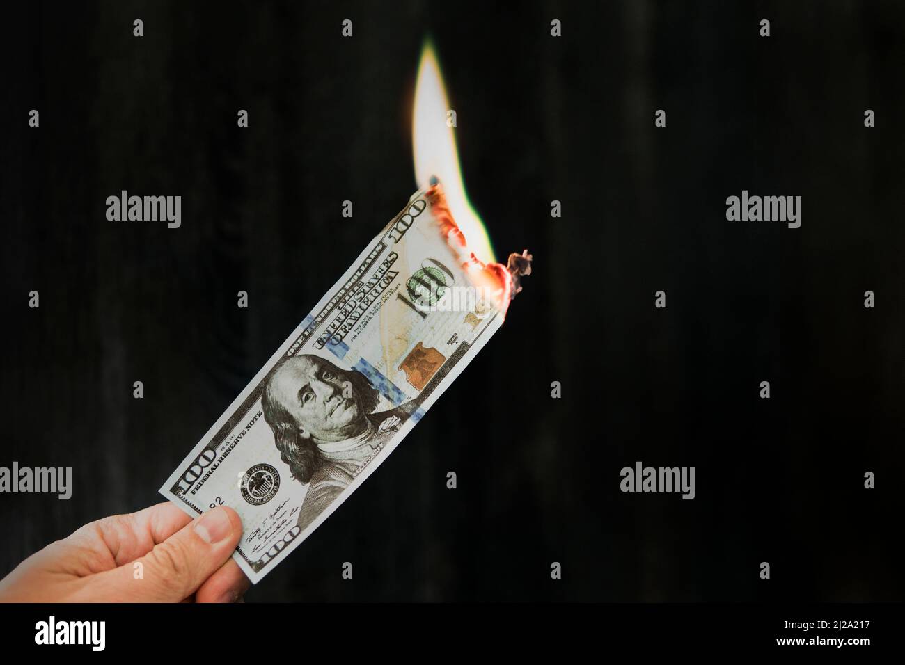fire on banknotes on a black background. concept of inflation, a ...