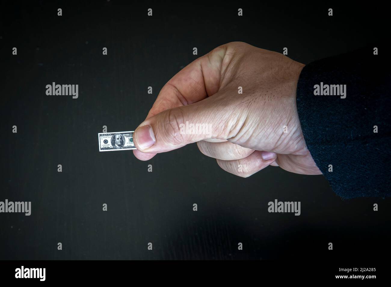 young businessman guy holds a small bill in his hand as a symbol of ...