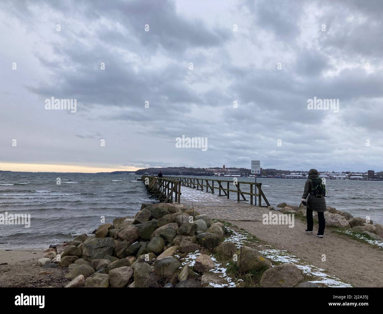 Flensburg, Germany. 31st Mar, 2022. A woman walks on the beach where there are still remnants of ...