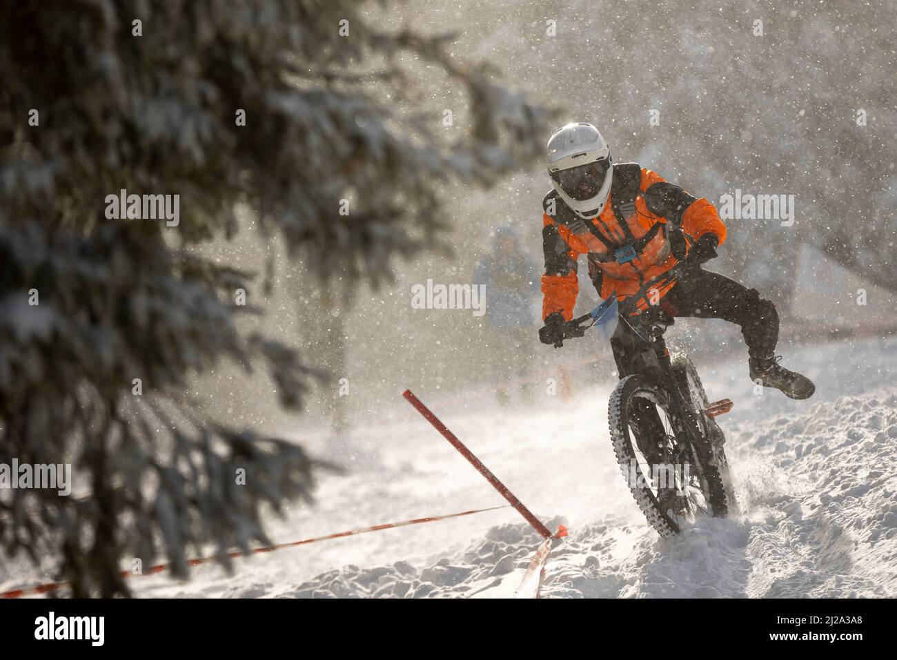 Cyclist rides a bike during an extreme snow downhill riding mountain ...