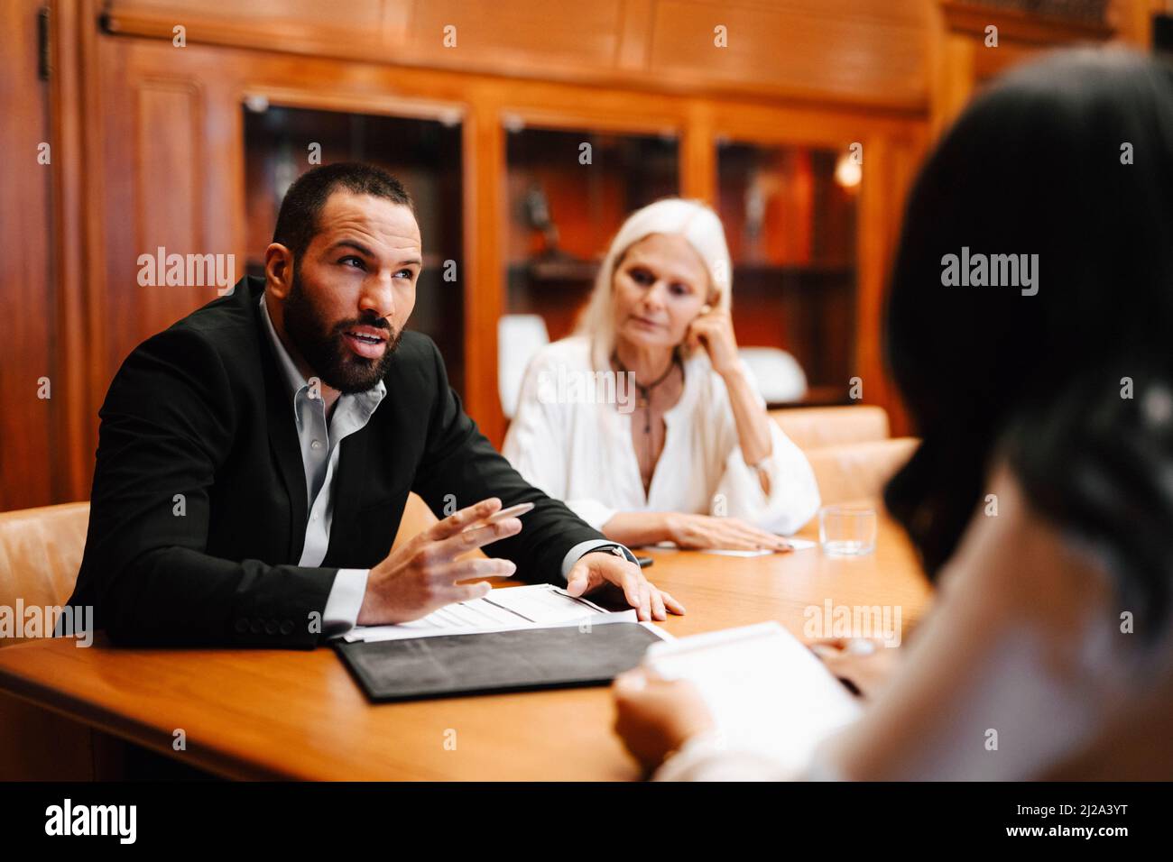 Male financial advisor discussing over contract document with female ...