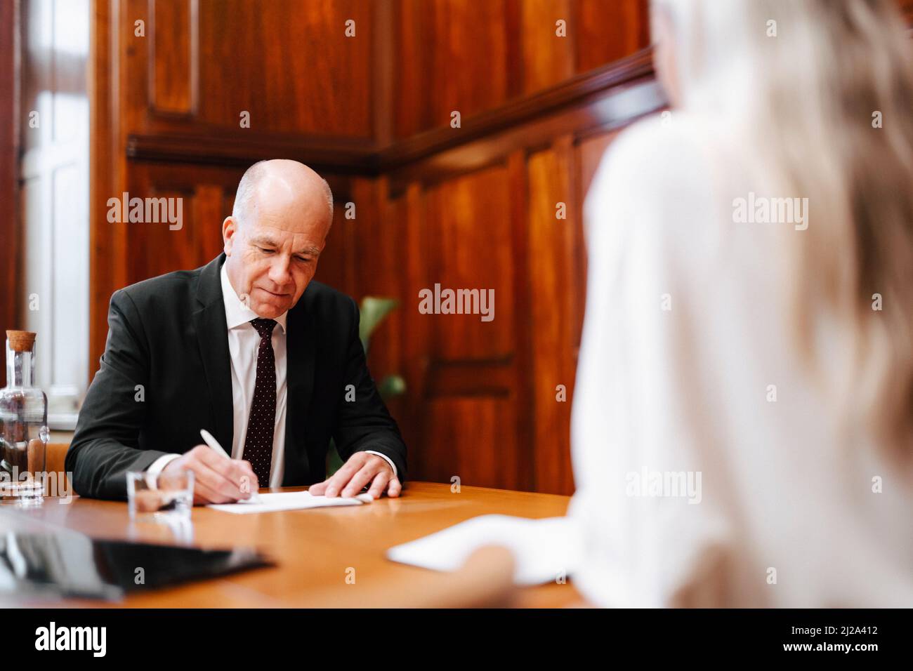 Senior businessman signing contract document with financial advisor in ...
