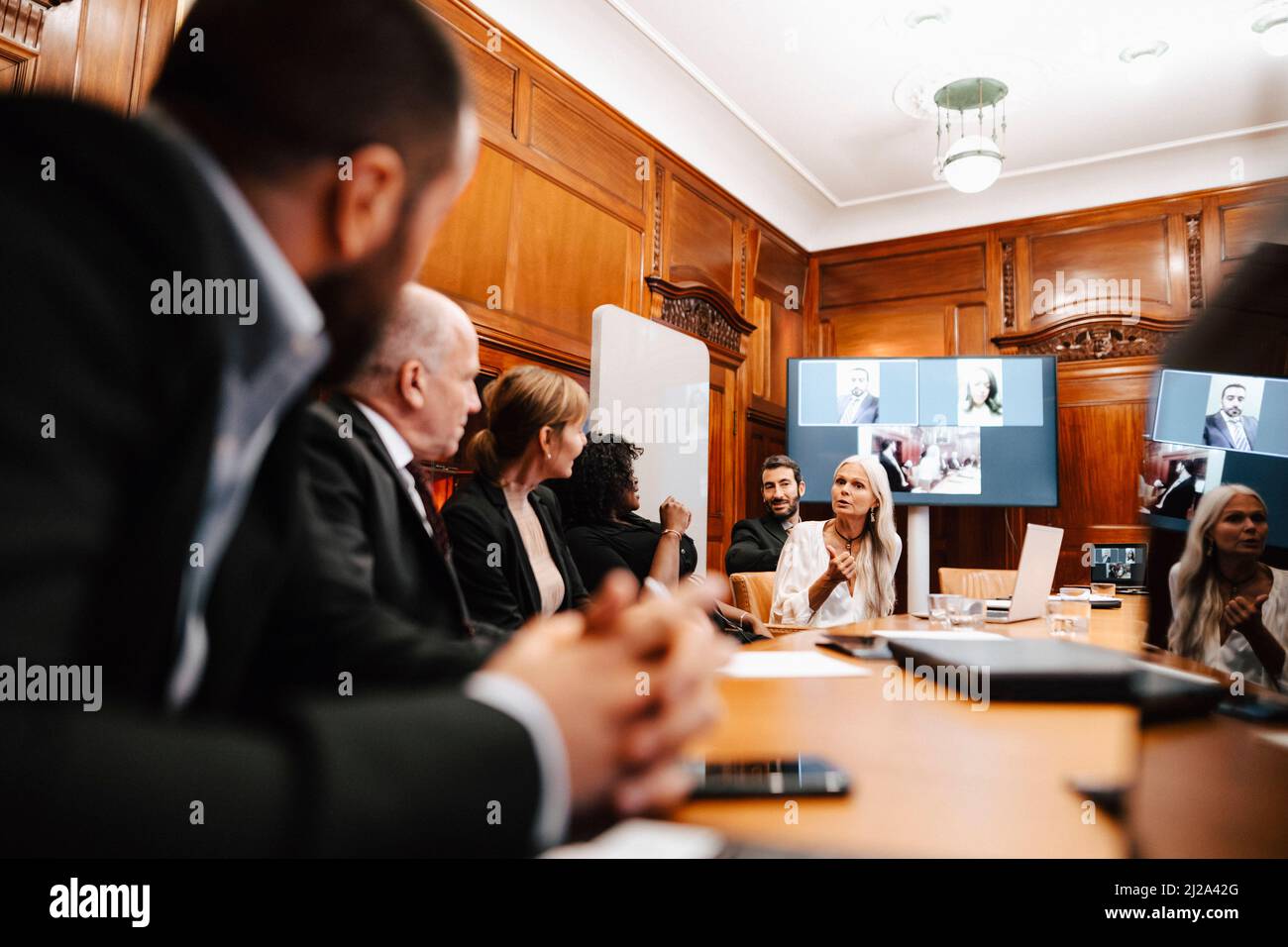Female financial expert discussing with colleagues in conference at ...