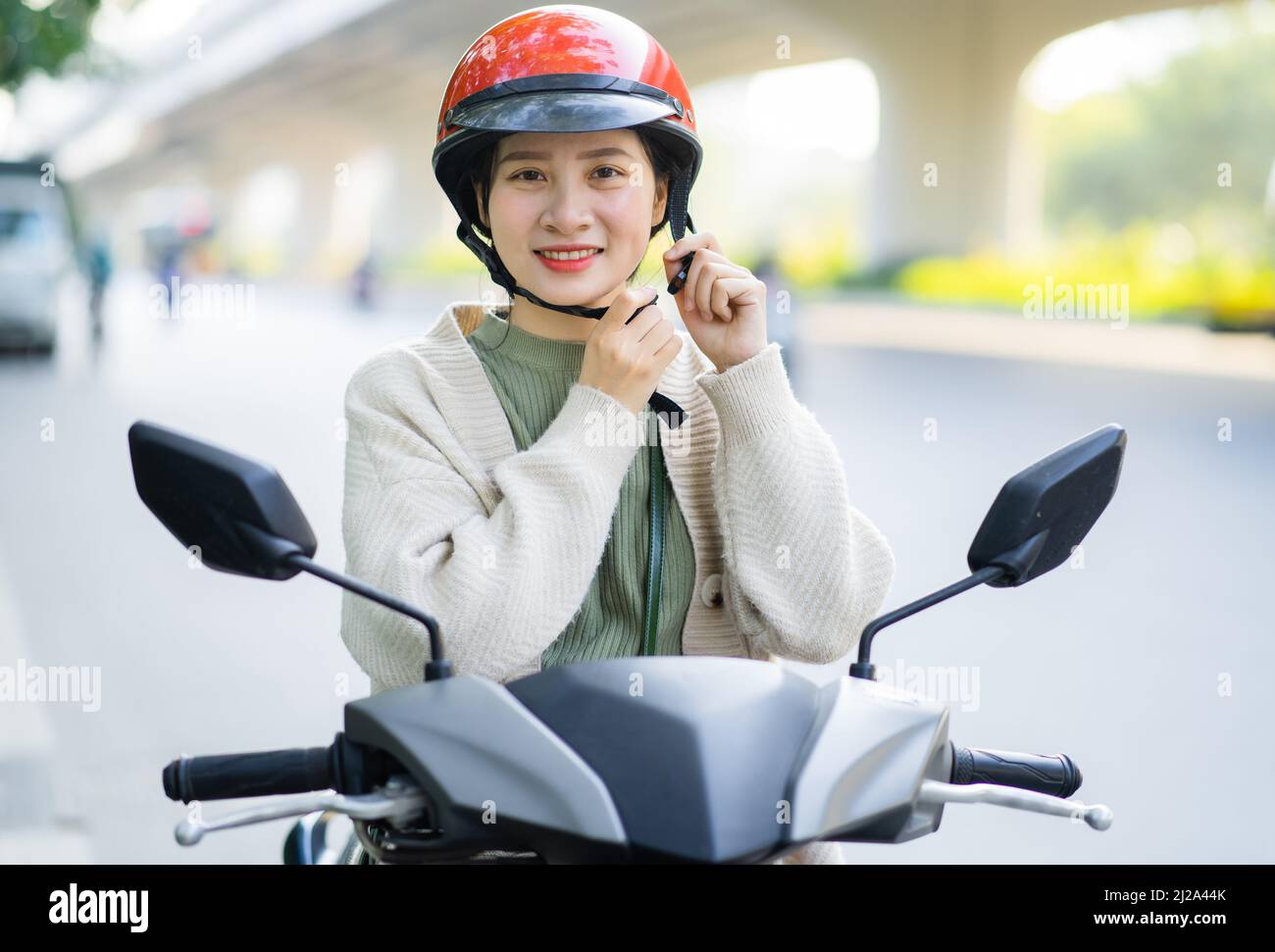 Asian woman driving a motorbike on her way to work Stock Photo - Alamy