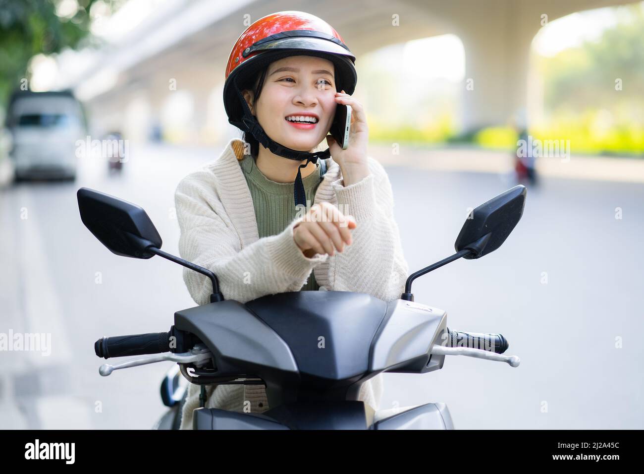Asian woman driving a motorbike on her way to work Stock Photo - Alamy