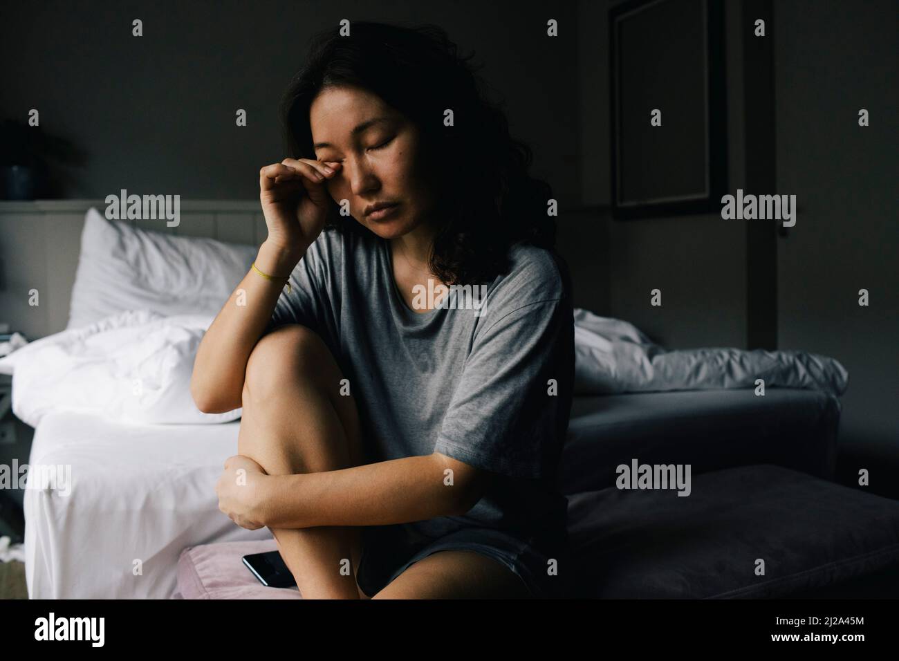 Mentally ill woman crying alone in bedroom at home Stock Photo - Alamy