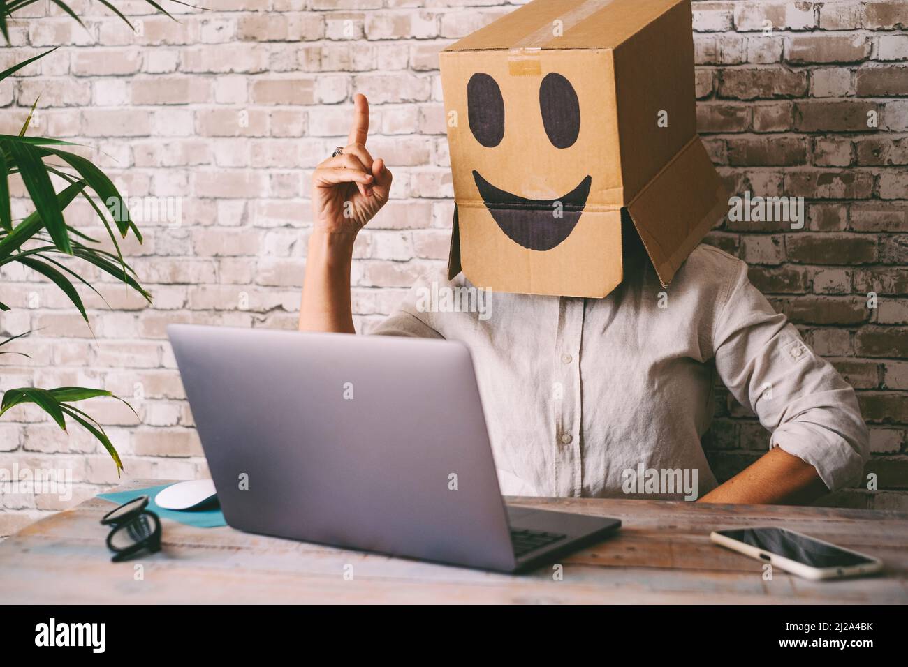 Happy and successful people working on computer wearing smile box on ...
