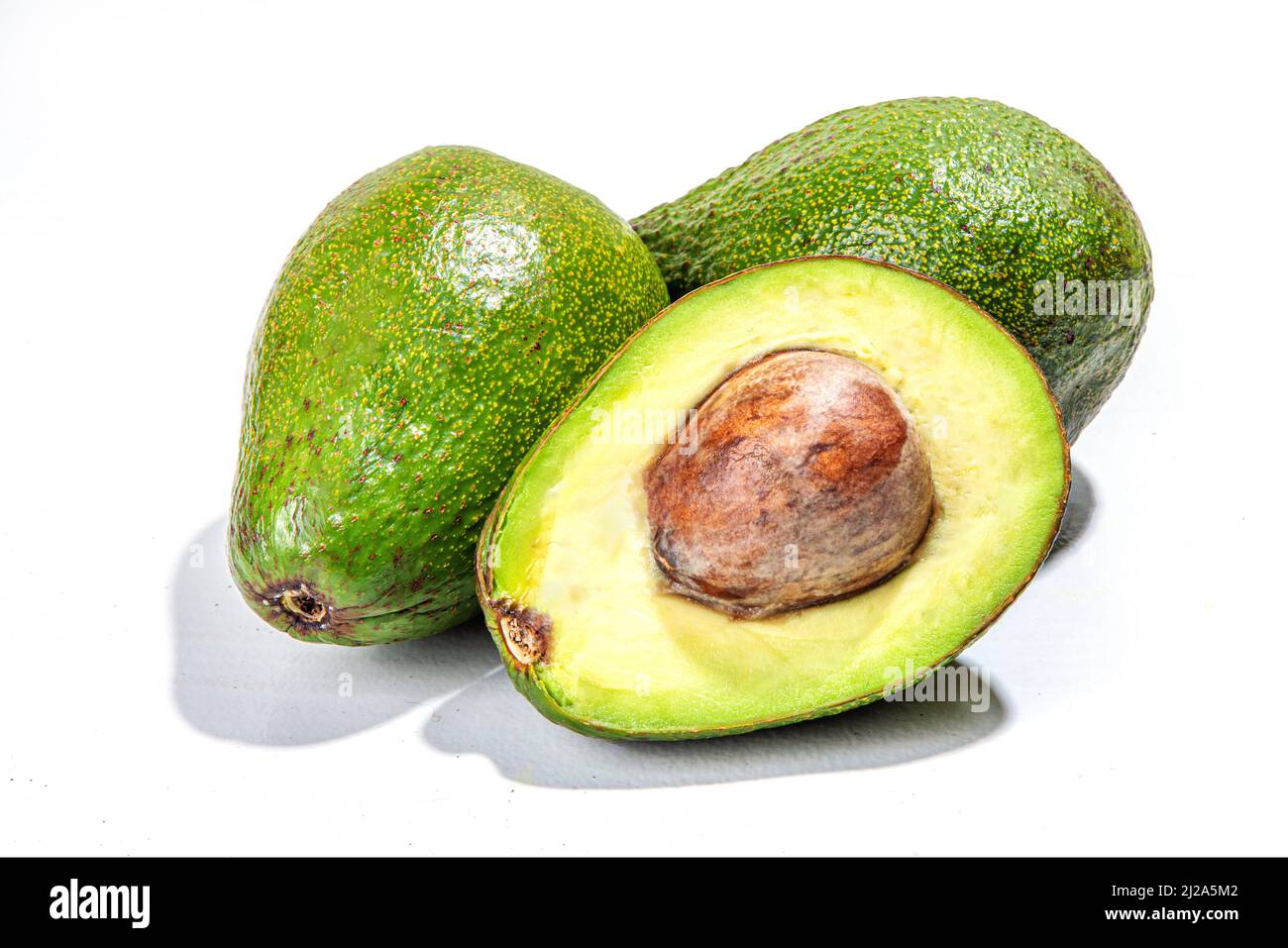 Fresh whole, half and sliced avocado. Isolated three raw avocados on ...