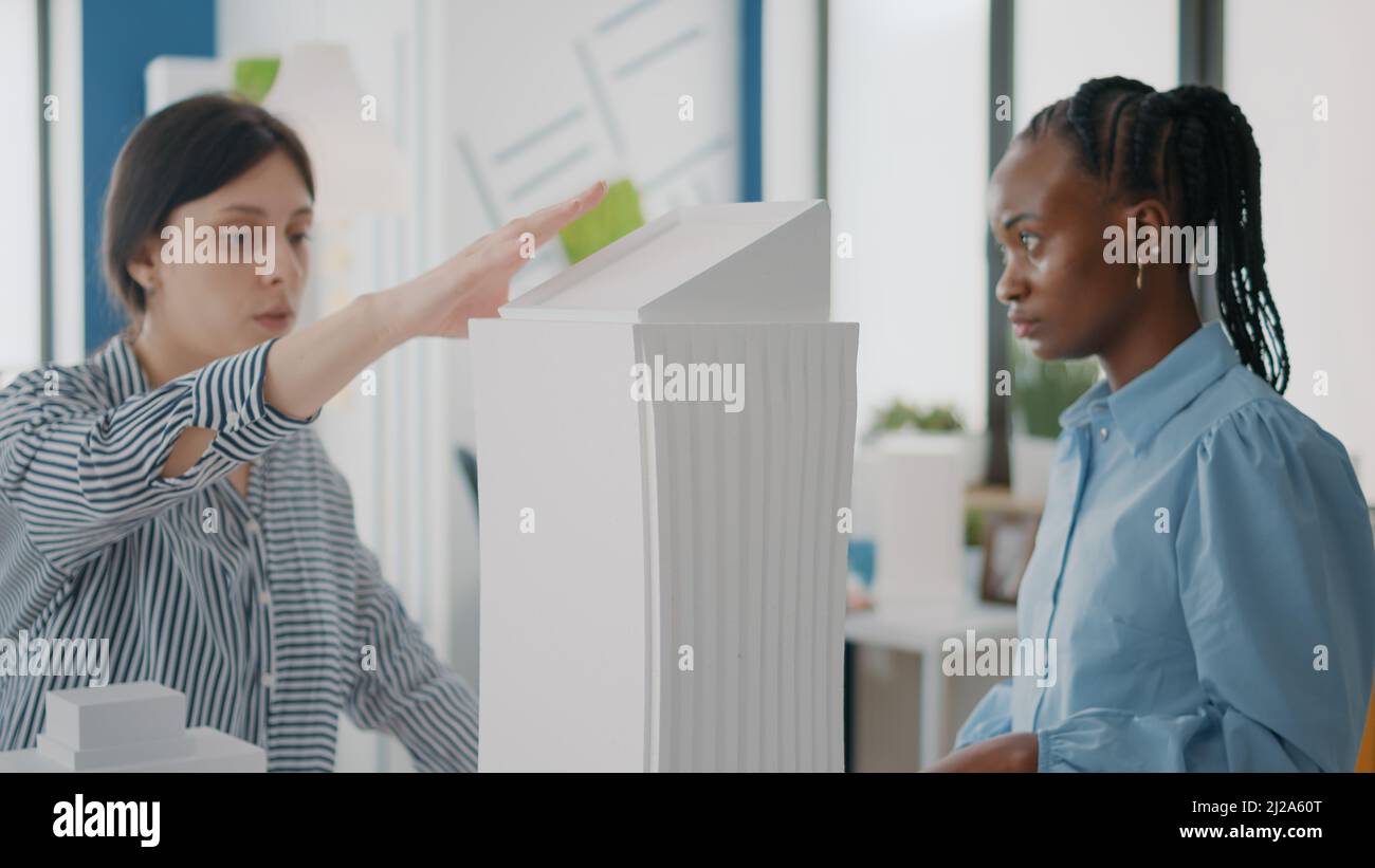 Close Up Of Building Model In Front Of Architects To Plan Construction Layout Maquette On Table