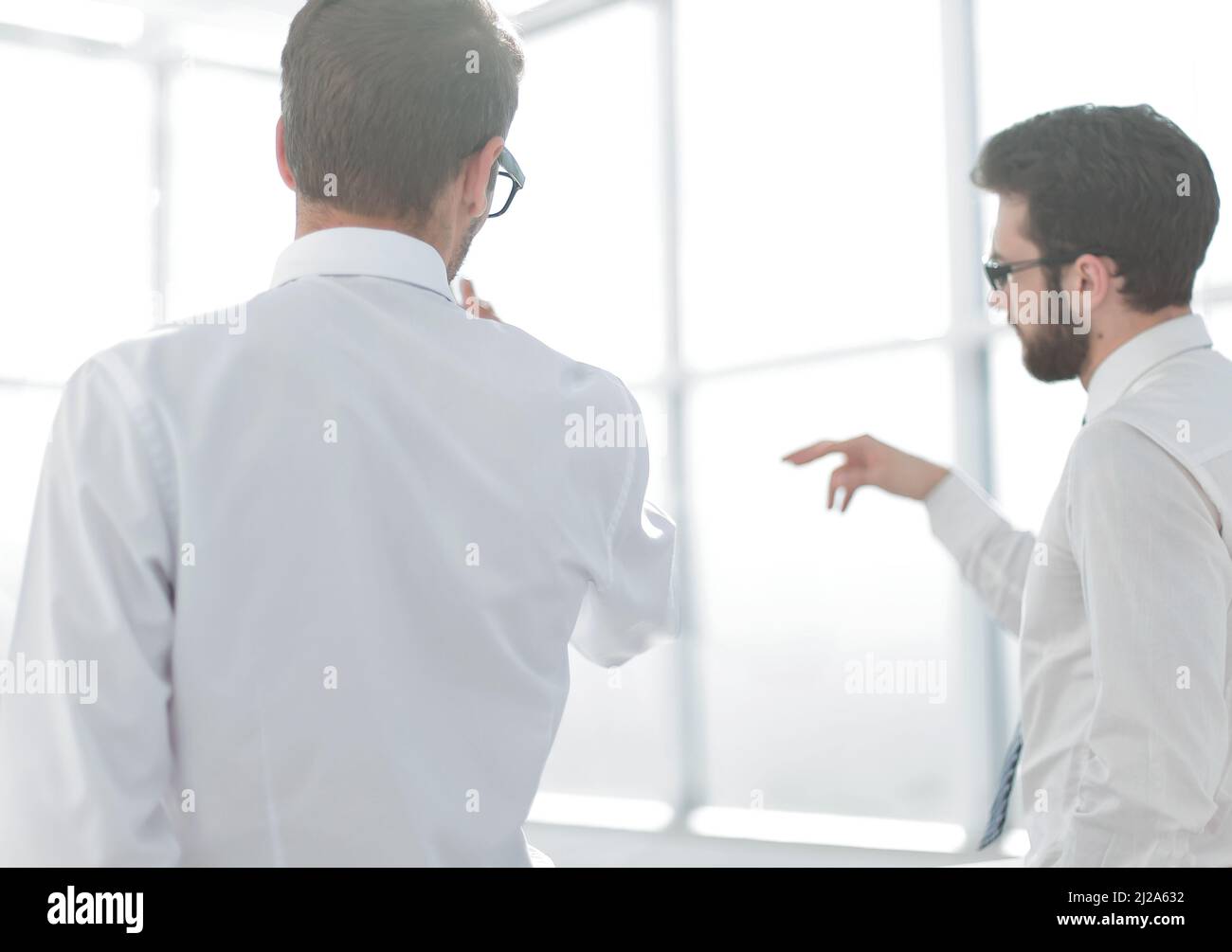 rear view.business partners looking through the office window Stock ...