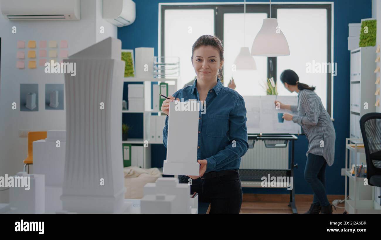 Portrait of employee working with building model and maquette to design ...