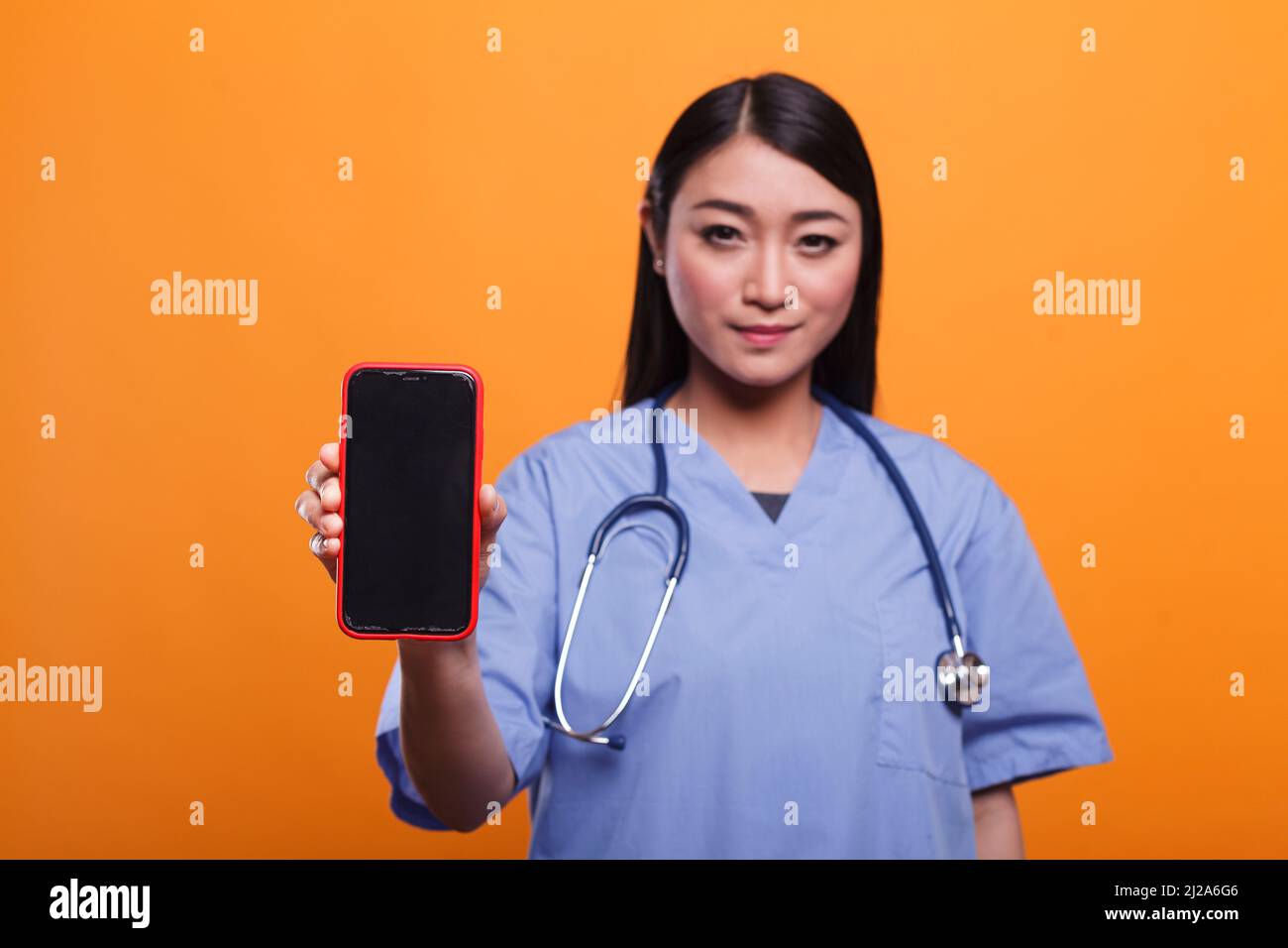 Hospital caregiver wearing medical instrument while holding mobile ...