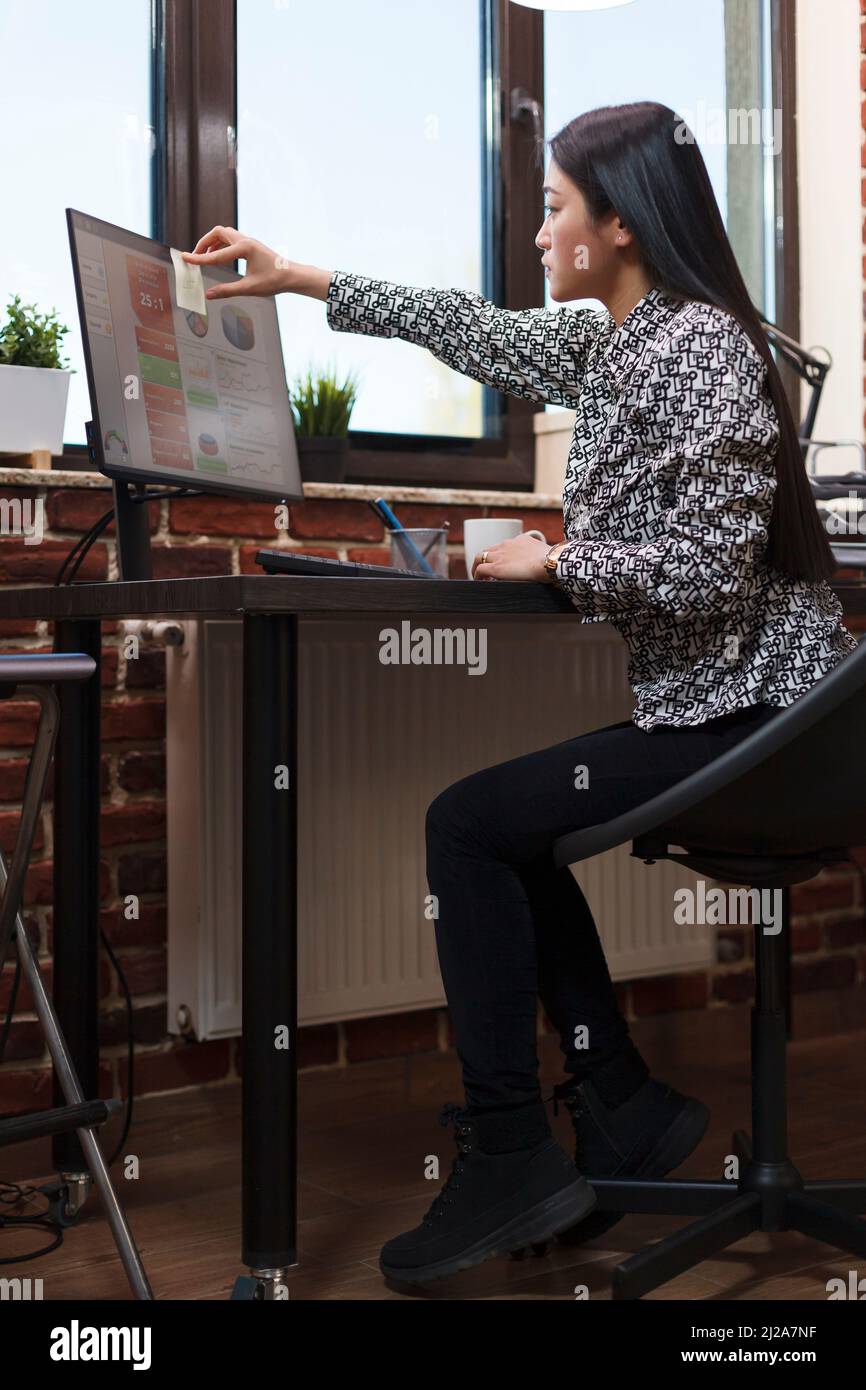 Marketing agency employee putting memo note on screen with vital client ...