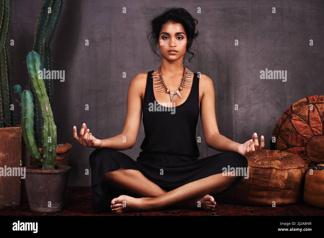 Meditating magic. Studio portrait of a beautiful young woman sitting in ...