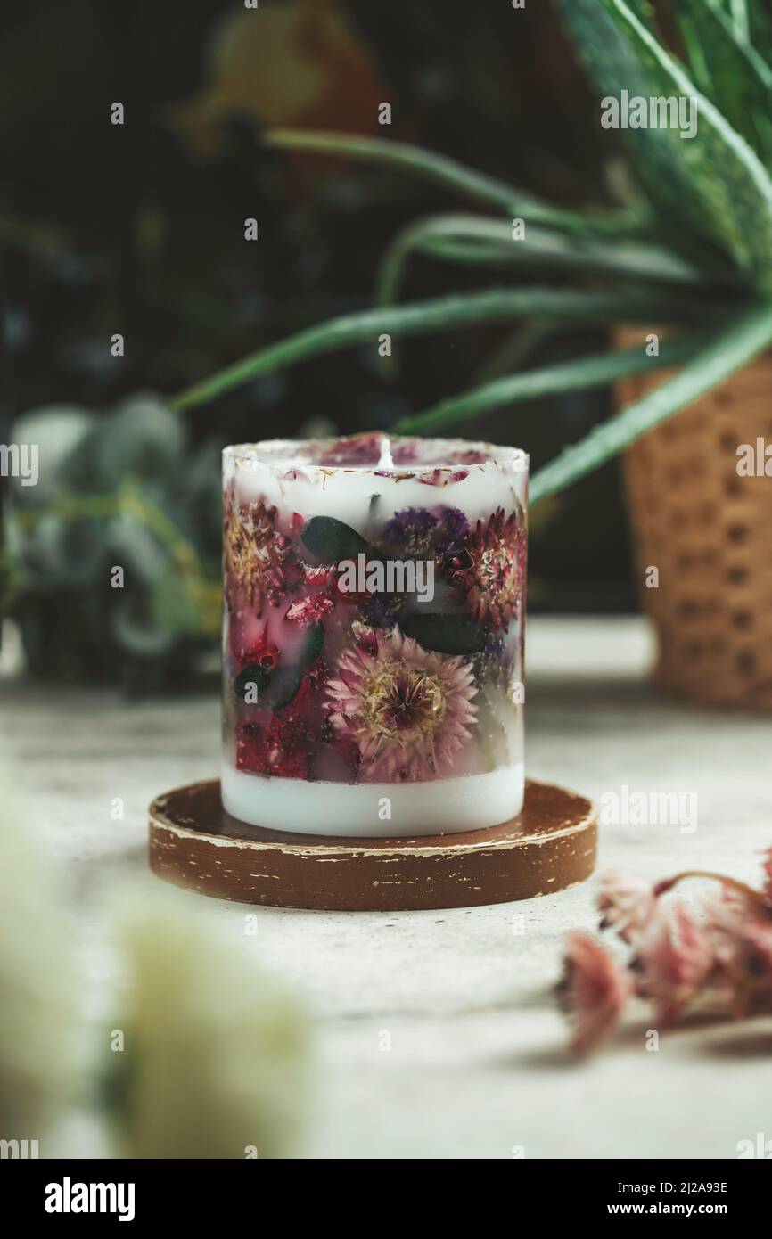 Handmade candles of a unique design, with different flowers, dry leaves ...