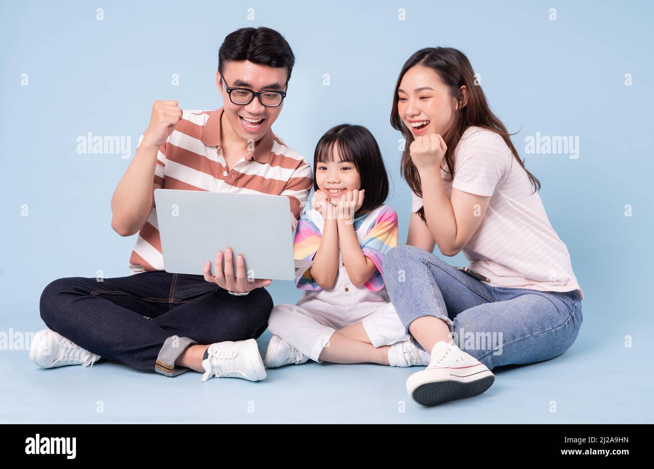Image of young Asian family using laptop on blue background Stock Photo ...