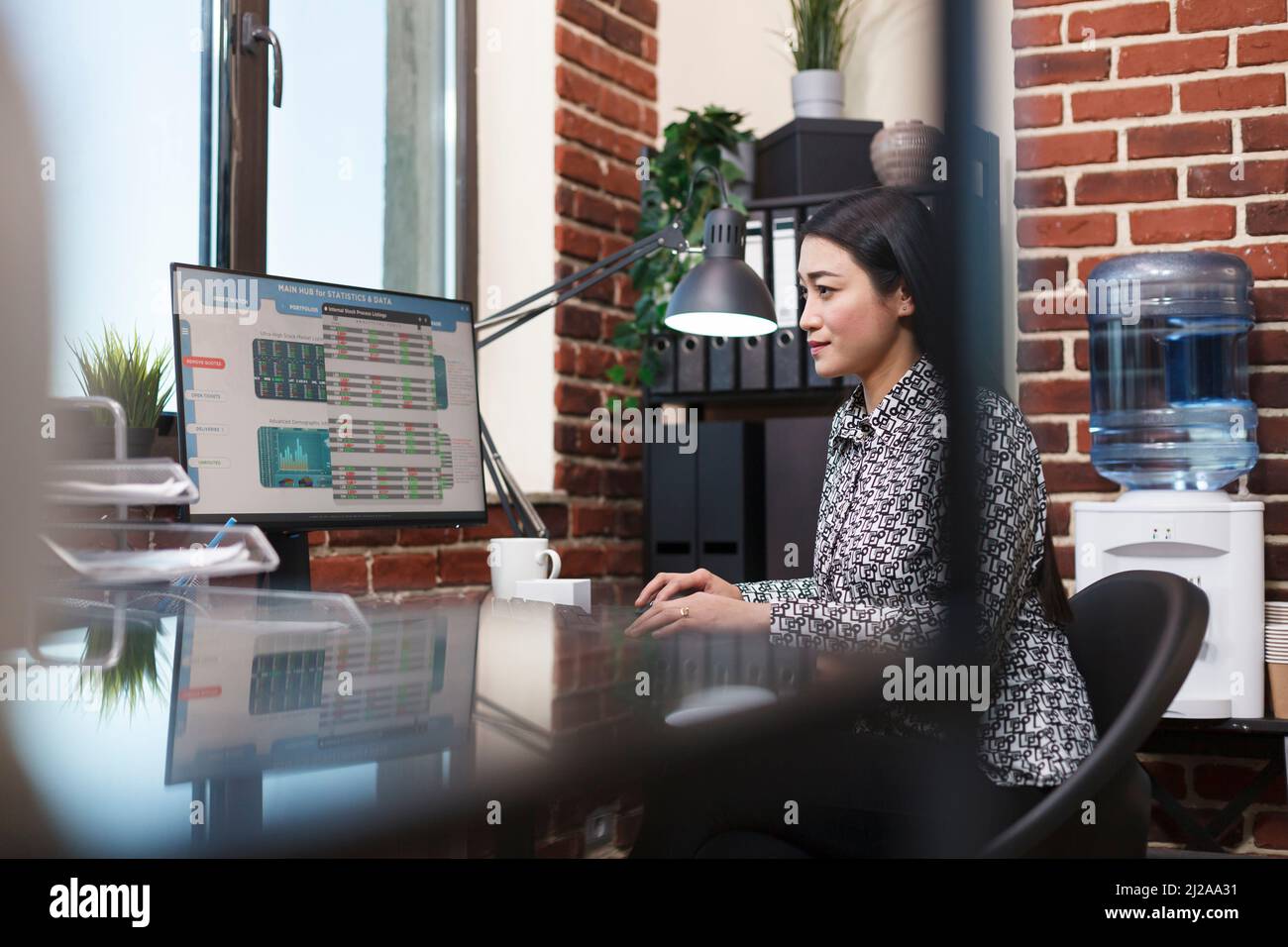 Young confident business woman reviewing startup project status charts ...