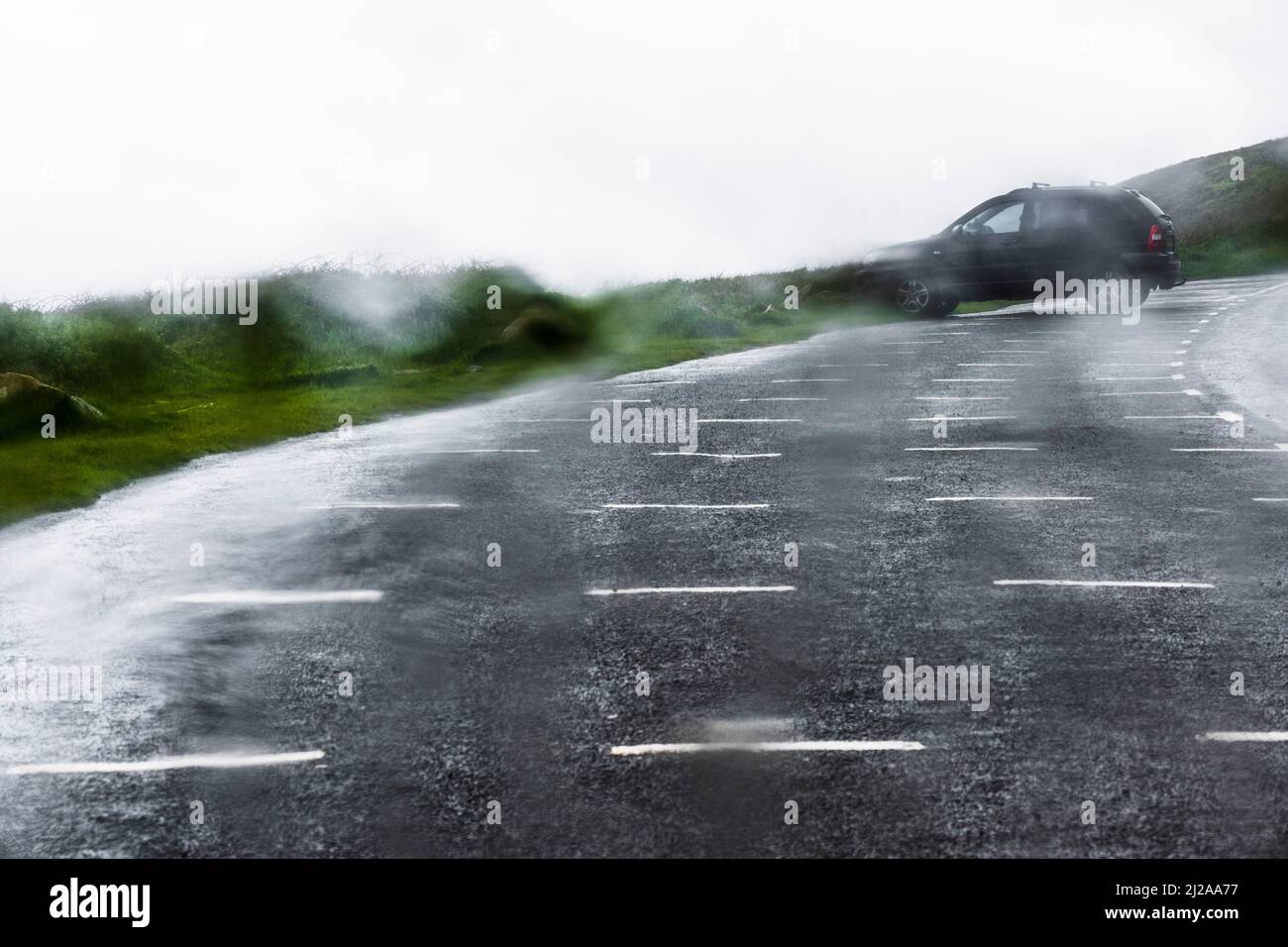 View through a car window parked on the coast on a wild stormy grey and ...