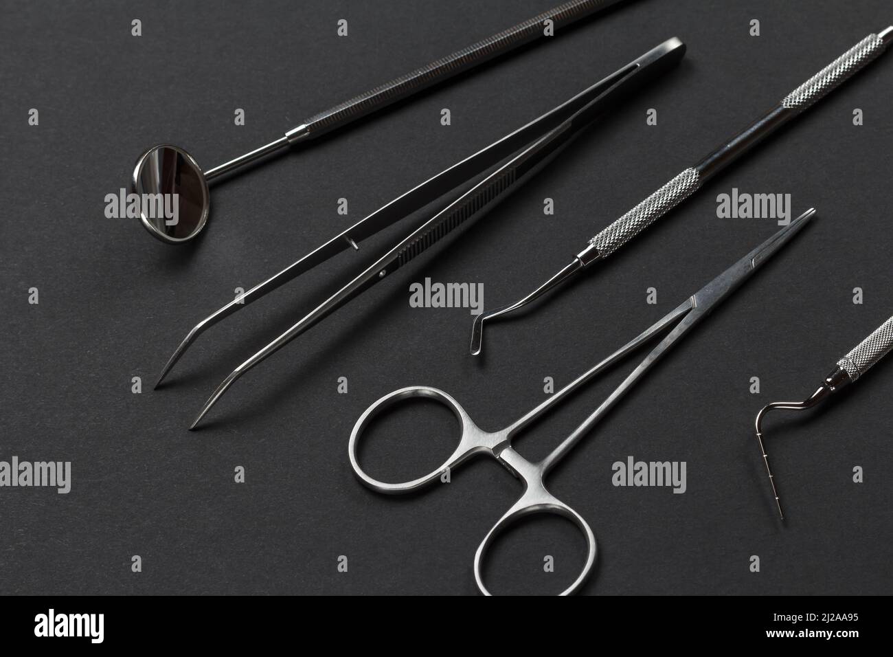 Set of metal instruments for dental treatment. Mouth mirror, tweezers ...