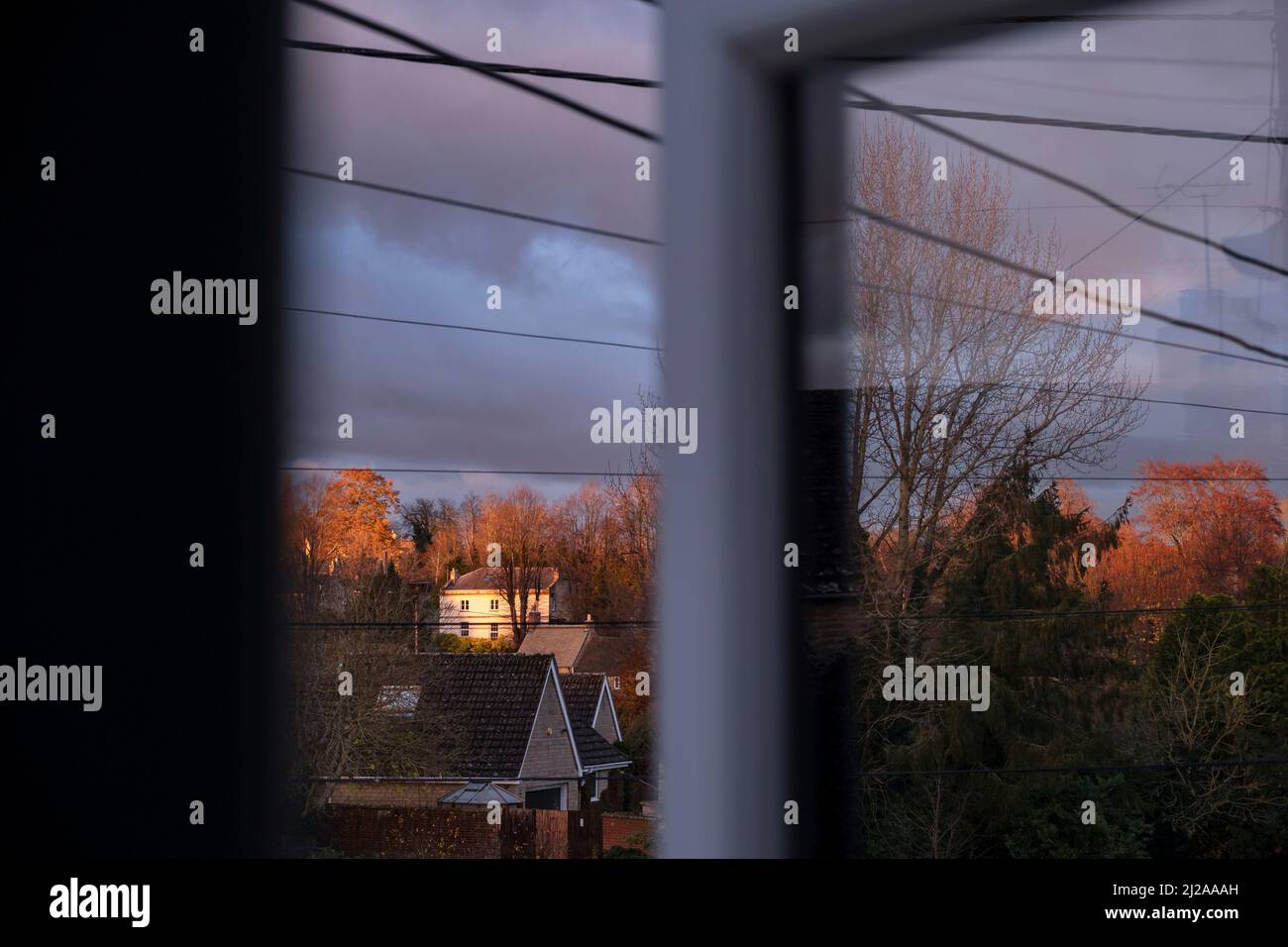 Looking out of a half open window across to other houses at sunset ...