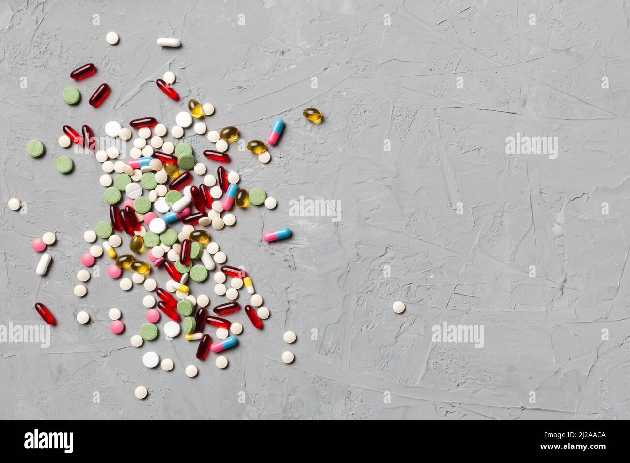 assorted pills and tablets top border over colored background. Many ...