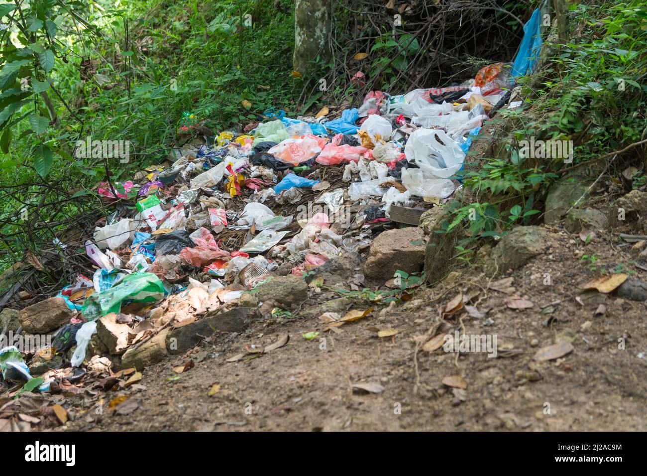 pile of plastic garbage in a backyard garden, environmental pollution ...