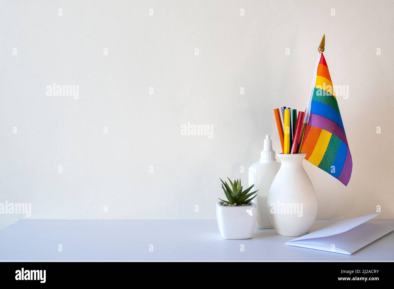 LGBT office, desk with rainbow flag and stationery, blank wall with ...