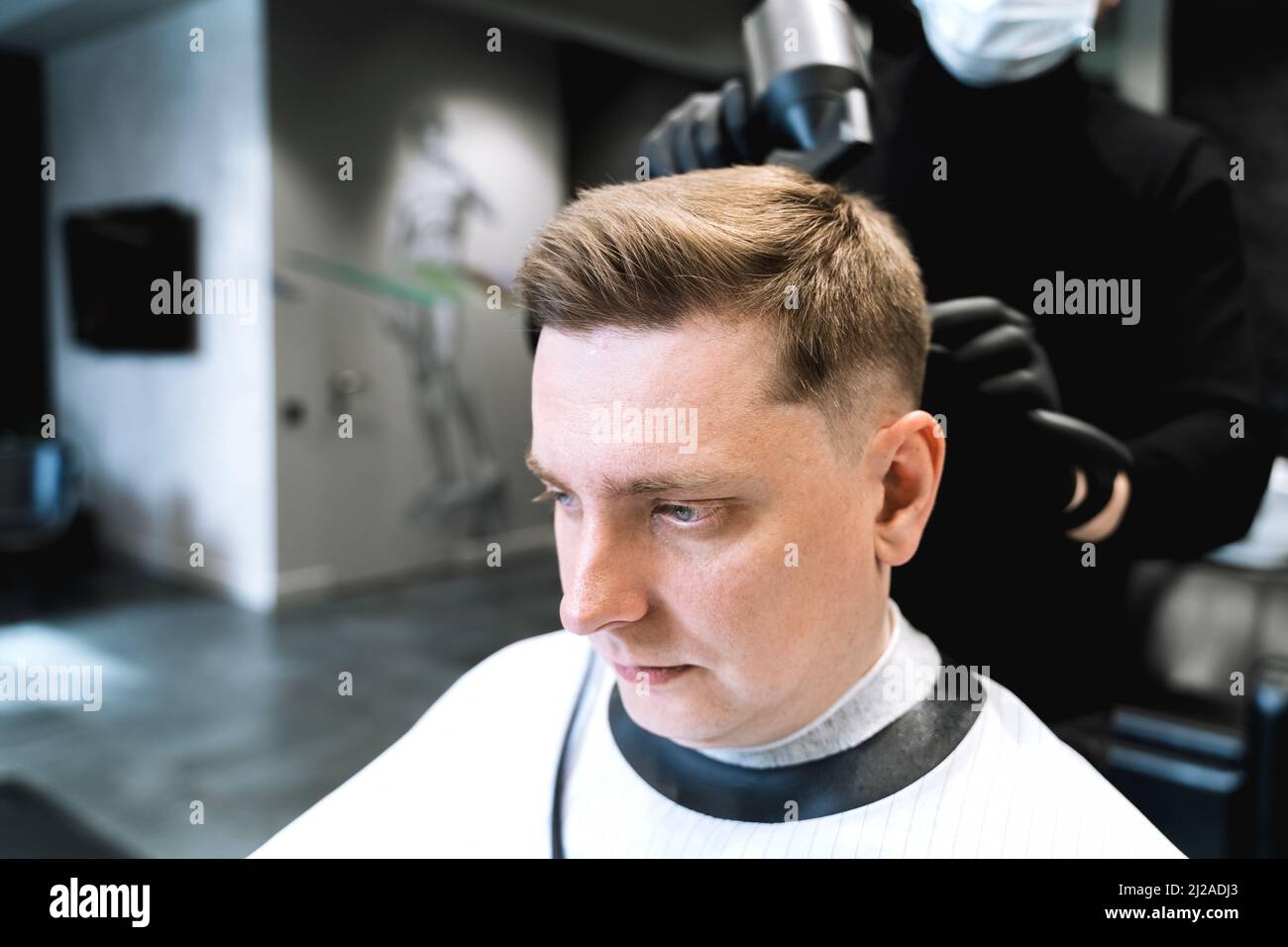 Visit to barbershop. Stylish man makes fashionable haircut. Barber ...
