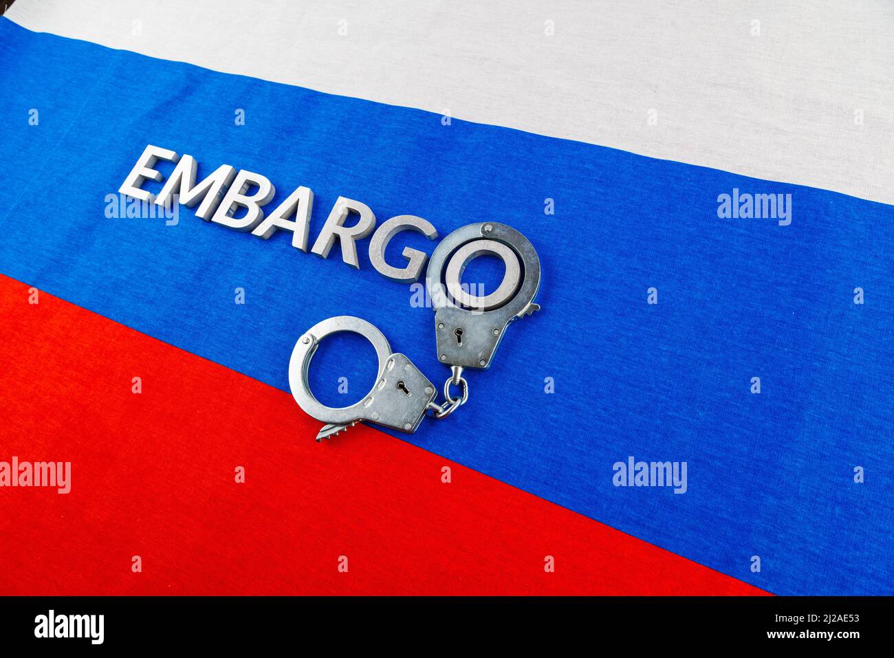 the word embargo laid with silver metal letters on russian tricolor ...