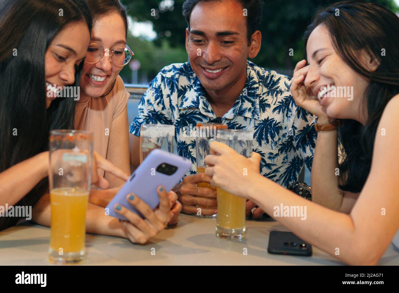 Group of friends in a bar and interacting with cell phones Stock Photo ...